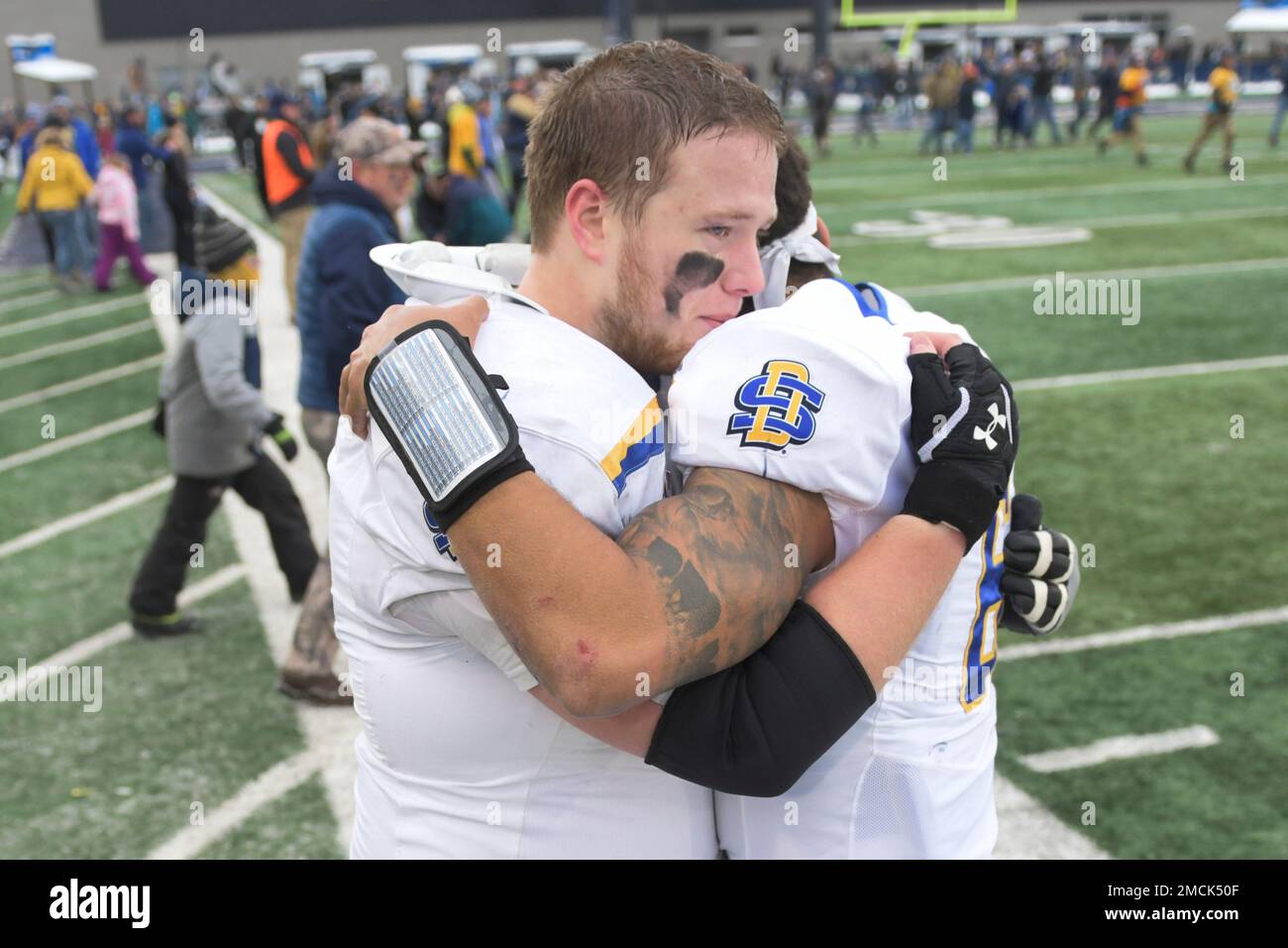 South Dakota State offensive lineman Wes Genant, left, hugs South ...