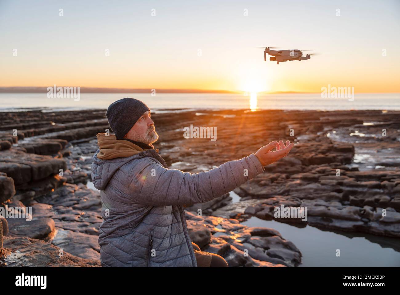 Bearded man using a drone with remote controller making photos and ...