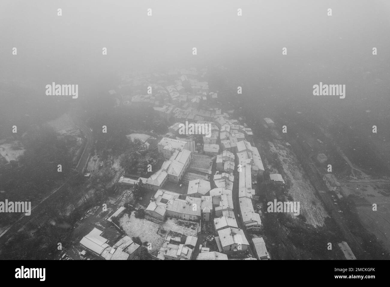Aerial shot of winter landscape near italian apennines town covered in ...