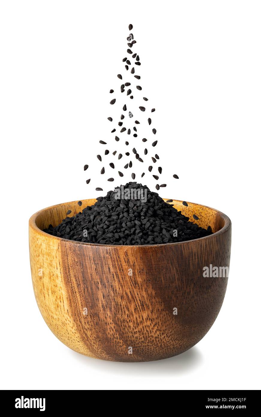 black cumin seeds falling in wooden bowl isolated on white Stock Photo ...