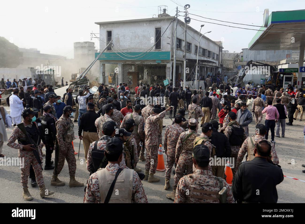 Pakistani security personnel and rescuers inspect the scene of a gas ...