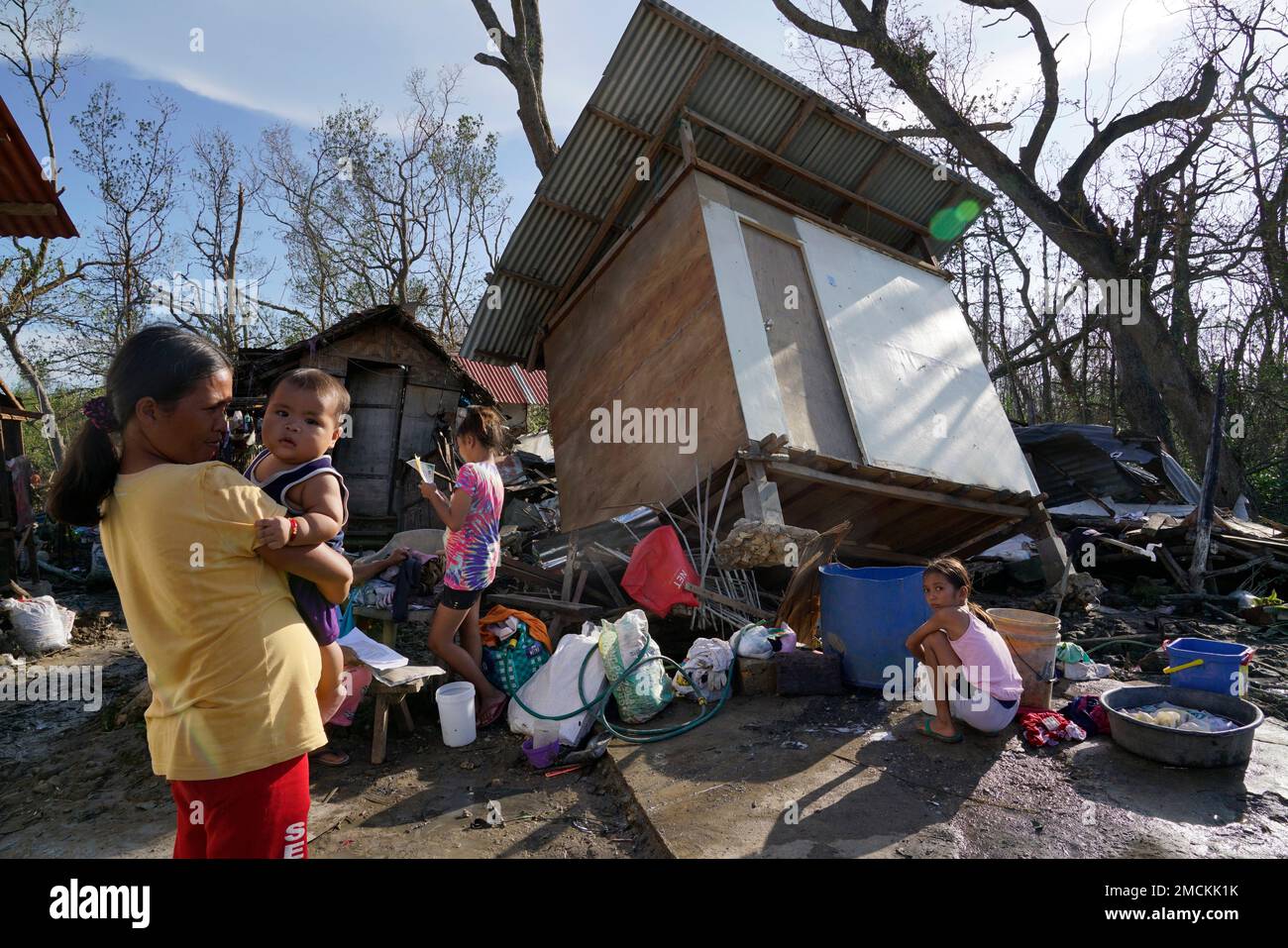 Residents stand amid damaged homes following Typhoon Rai in Talisay ...