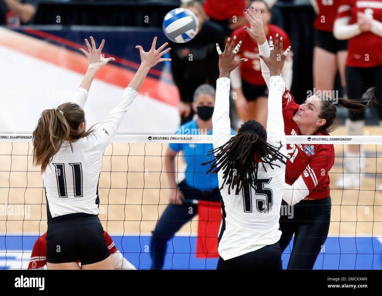 Wisconsin's Grace Loberg, right, spikes the ball in front of Louisville ...
