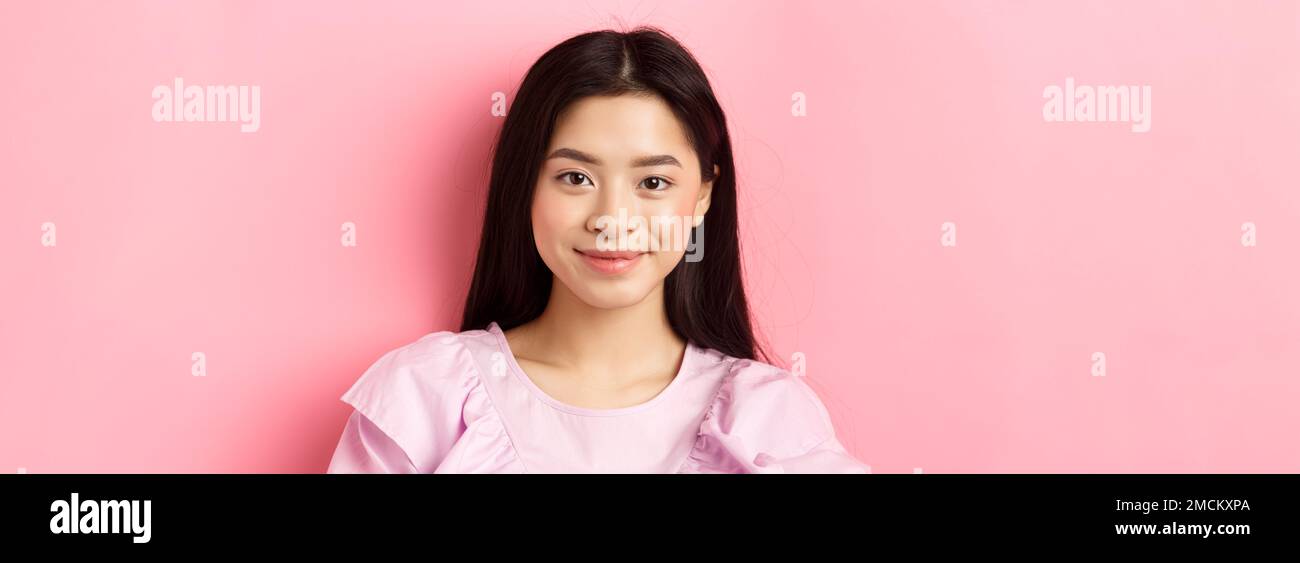 Close-up of beautiful asian woman looking happy, smiling cute at camera ...