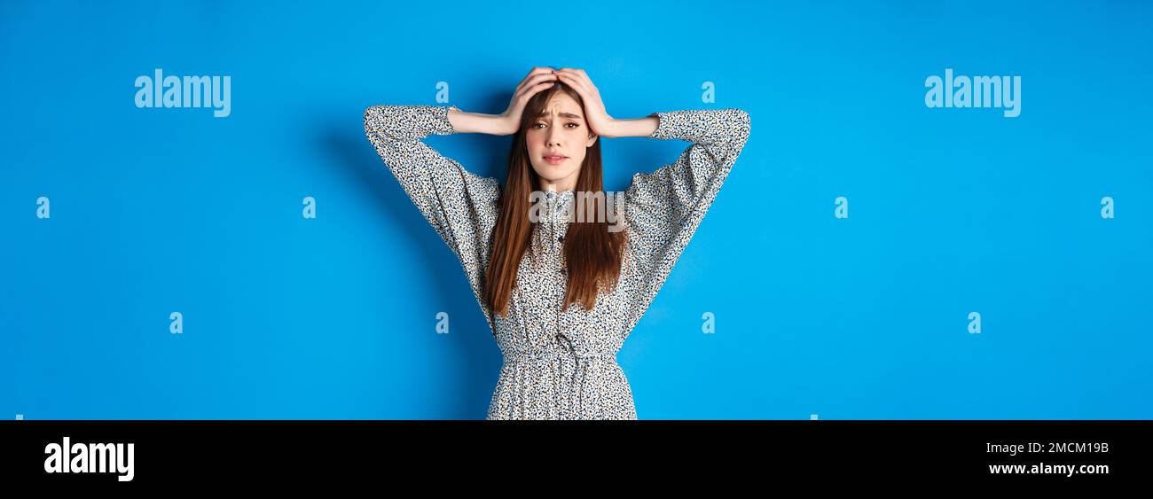 Frustrated adult woman with natural hair holding hands on head and ...