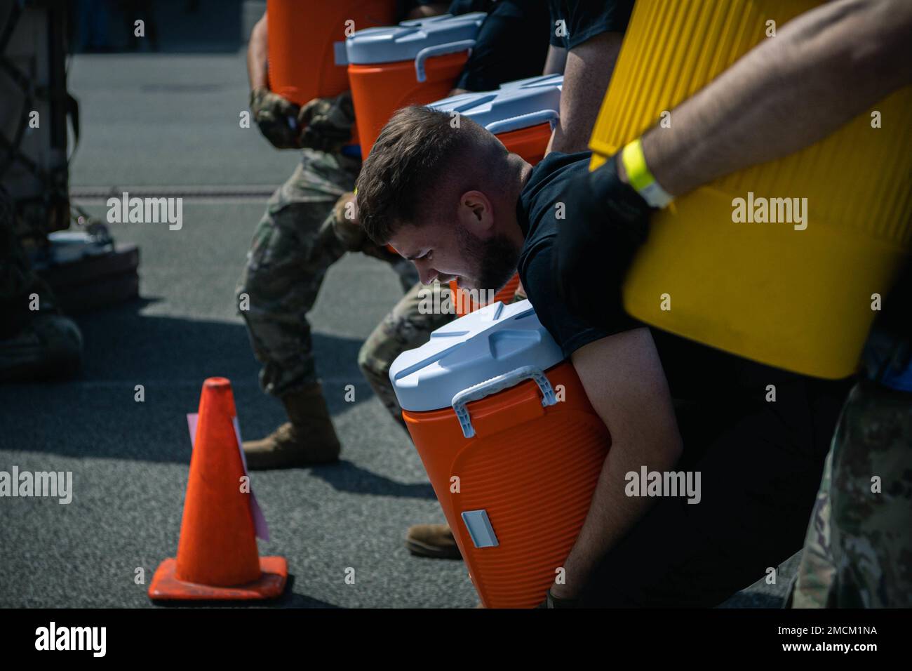 Members of the 727th Air Mobility Squadron carry weighted coolers ...