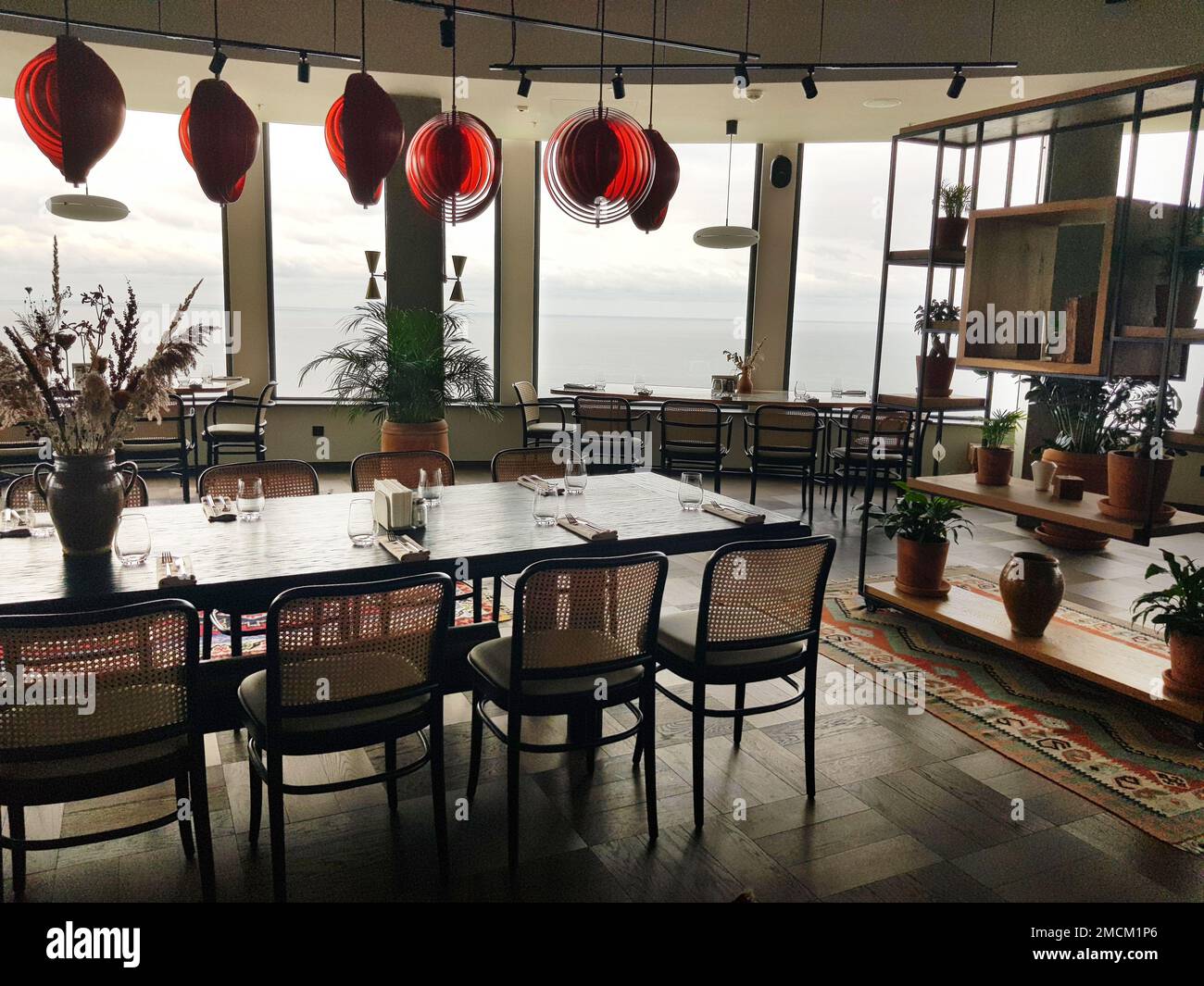 Restaurant table with chairs, beautiful interior and panoramic windows ...
