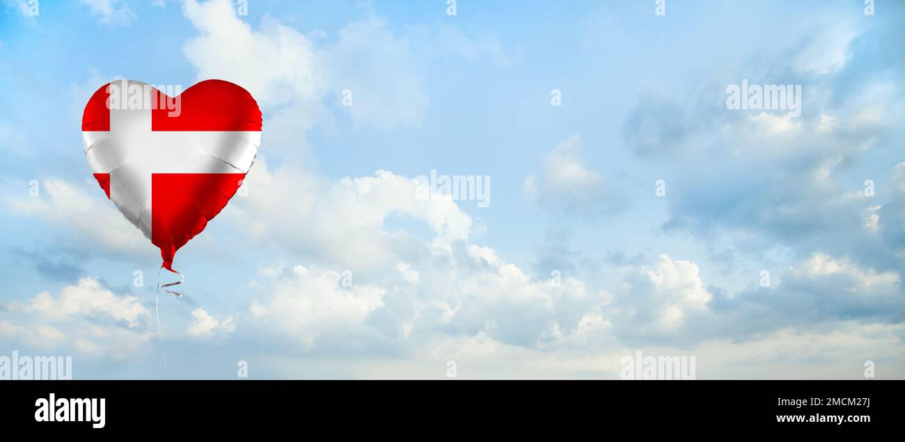 Flag of Denmark on heart-shaped balloon against sky clouds background ...