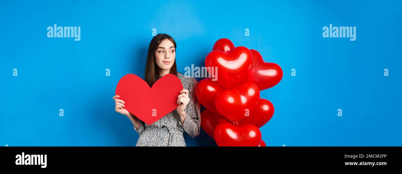Valentines day. Romantic girl in dress standing near balloons and ...
