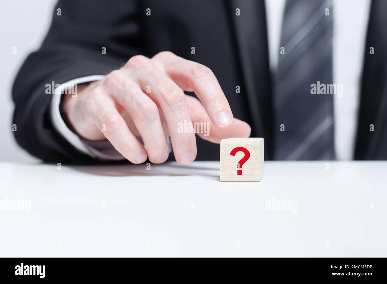Red question mark on wooden block pyramid in businessman hand. FAQ ...