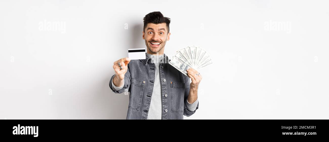Image of handsome guy holding dollar bills but suggesting use plastic ...