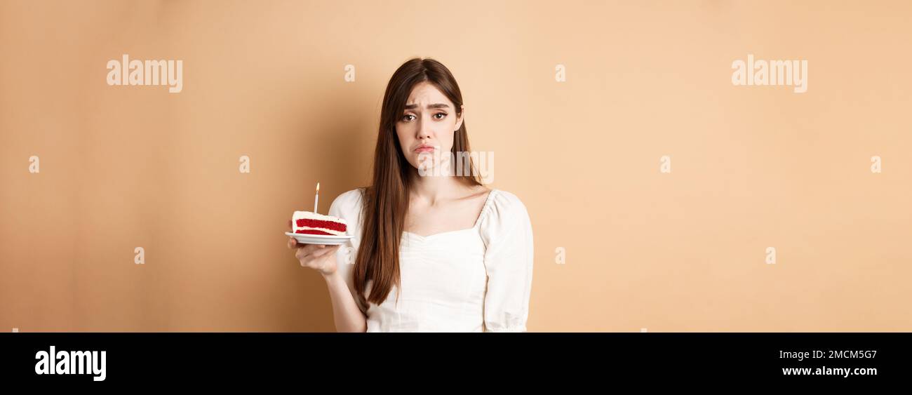Sad birthday girl holding cake with candle and look upset, feeling ...