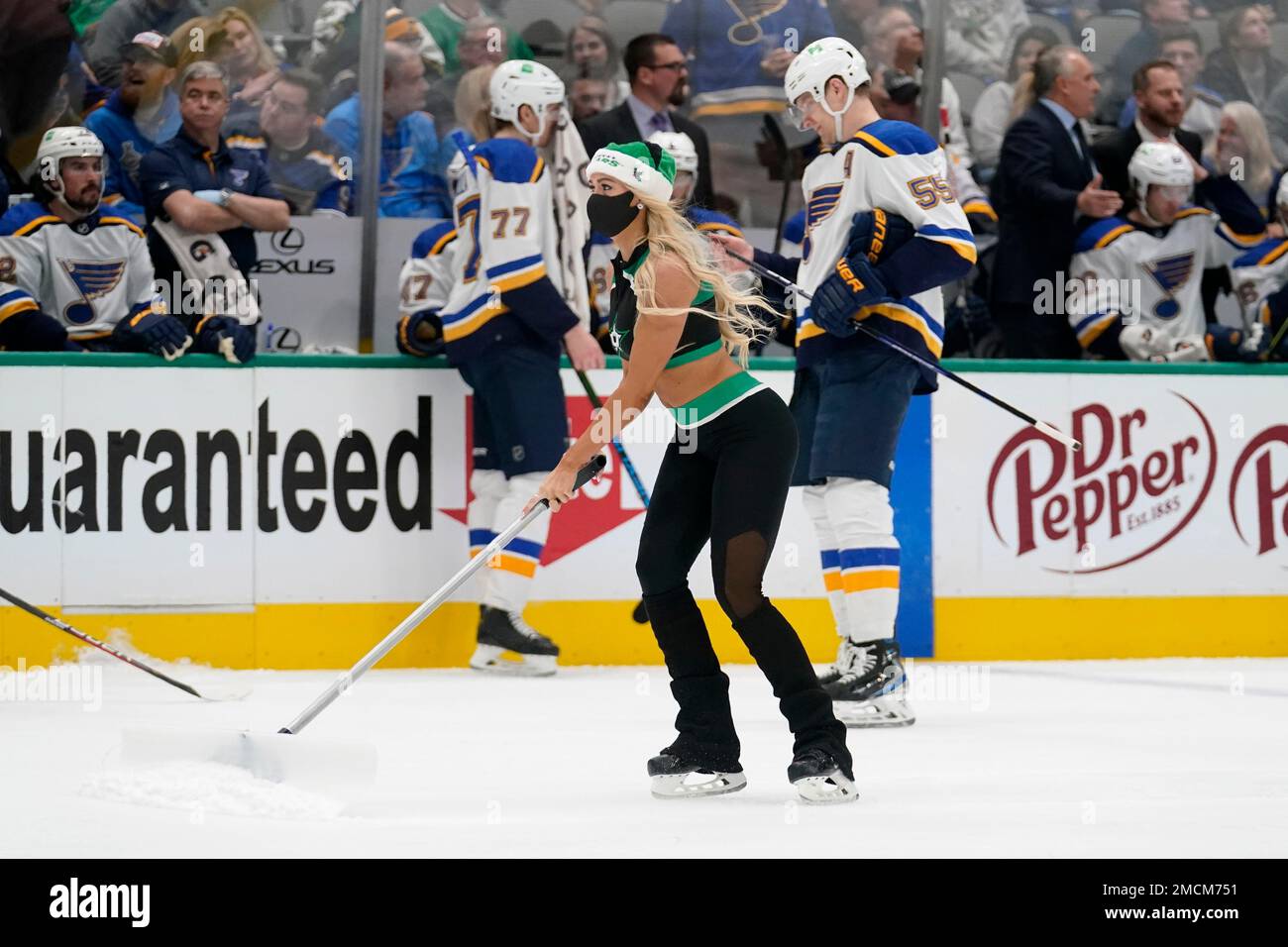 Members of the Dallas Stars Ice Girls clear frost off the rink during ...