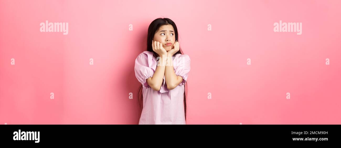 Sad and lonely asian girl look left and frowning, standing distressed ...