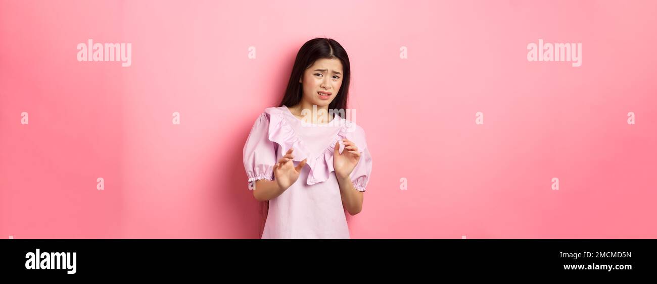 Stay away from me. Disgusted asian girl raising hands to block someone ...