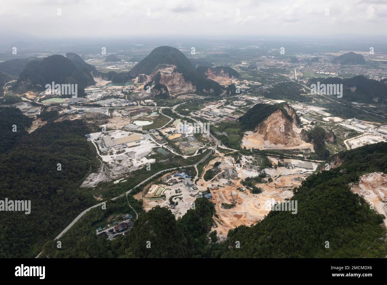 FILE - Deforestation surrounds massive limestone quarries cut into the ...