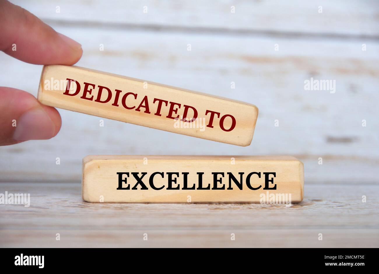 Dedicated to excellence text on wooden blocks with wooden cover ...