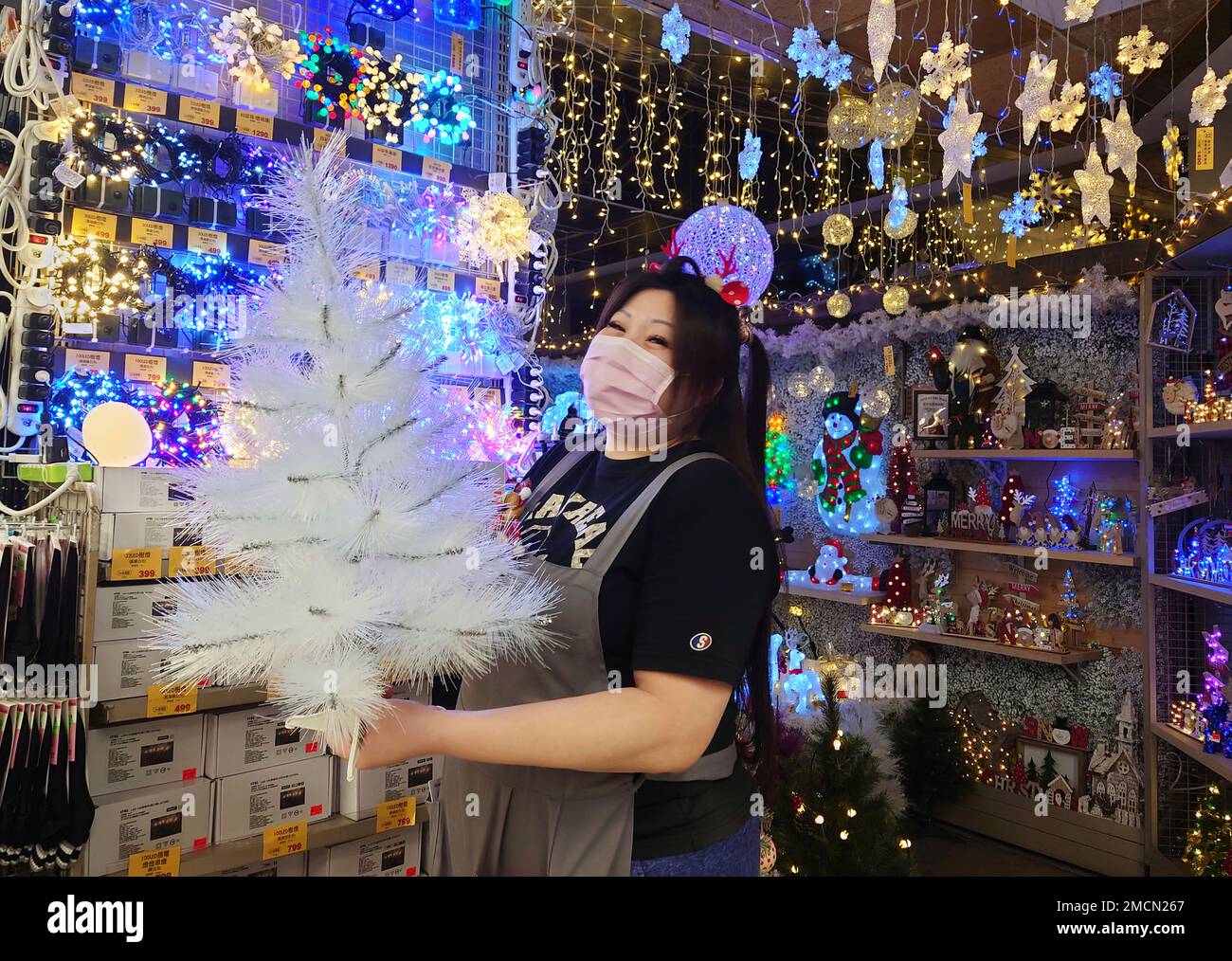 A worker wears a face mask to protect against the spread of the ...