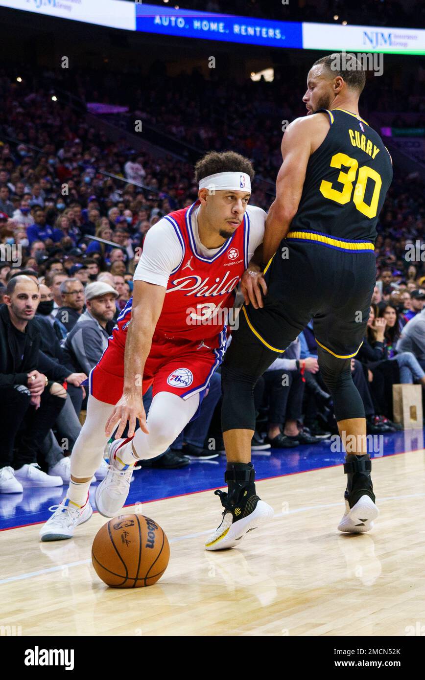Philadelphia 76ers' Seth Curry, left, drives past Golden State Warriors ...