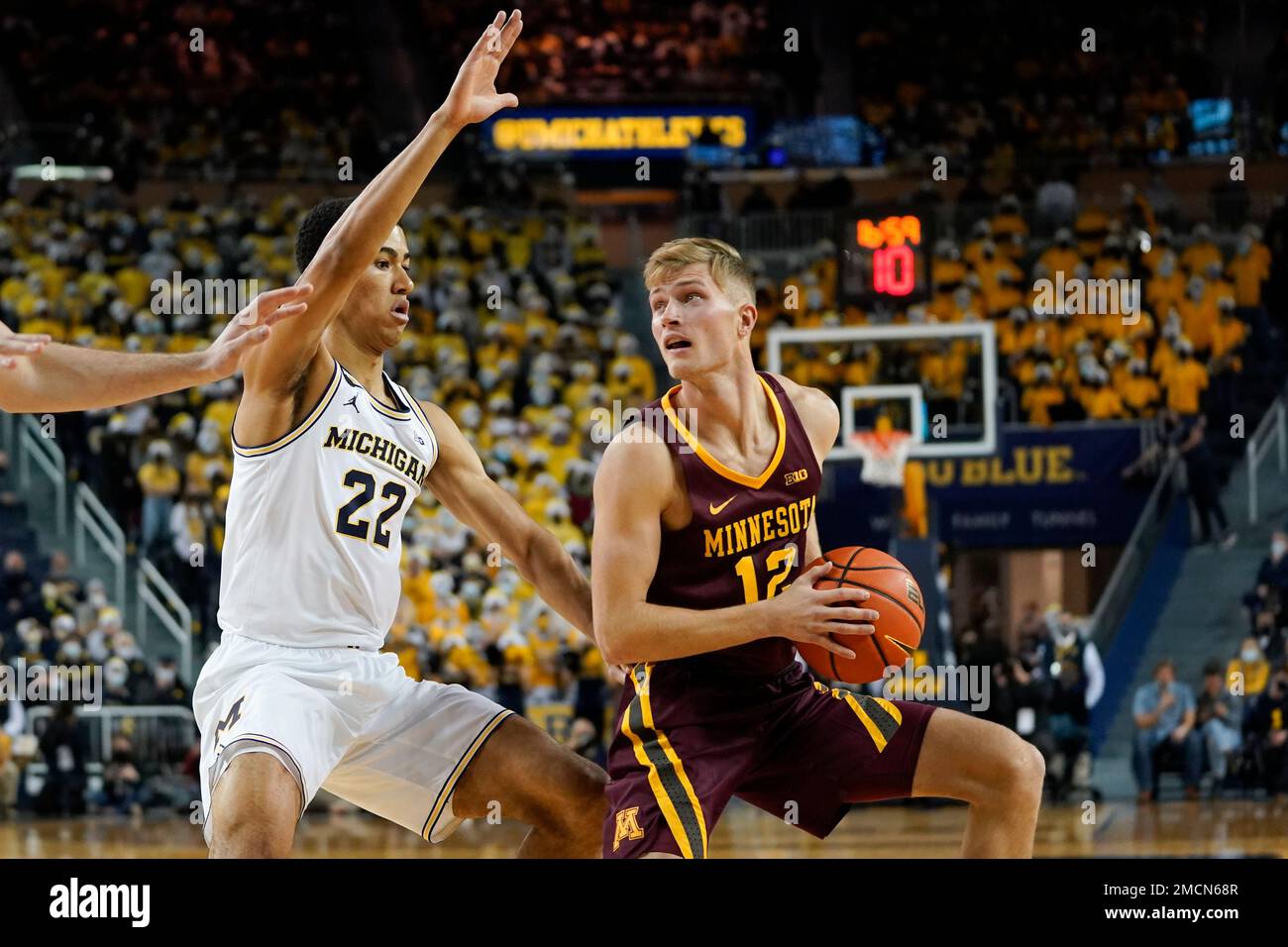 Minnesota's guard Luke Loewe (12) steps back on Michigan's forward ...