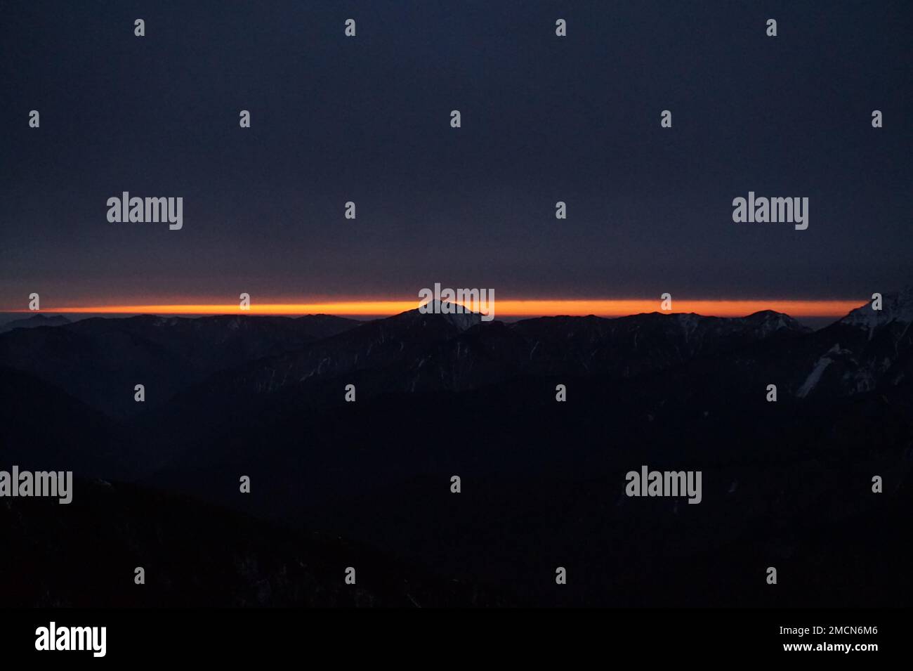 Bright orange sunset over mountainous terrain Stock Photo - Alamy