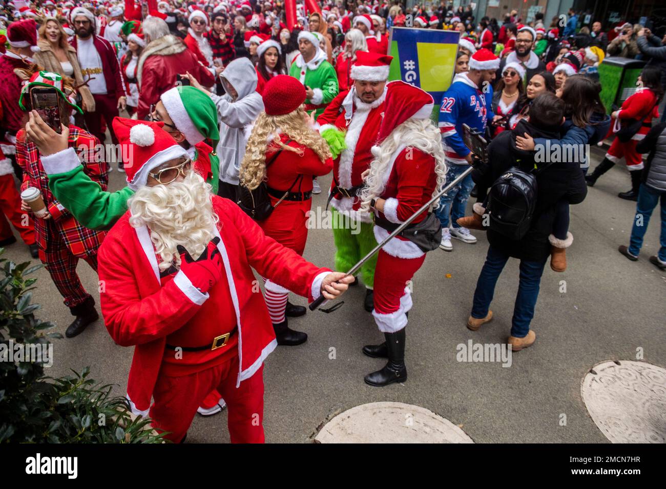 People dance and take photos at the start of Santa Con near Times ...