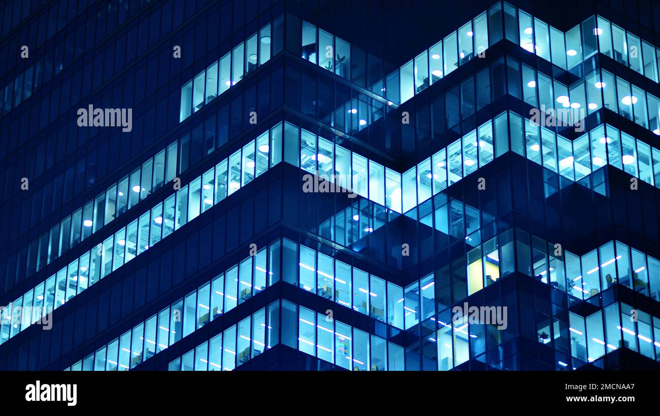 Pattern of office buildings windows illuminated at night. Glass ...