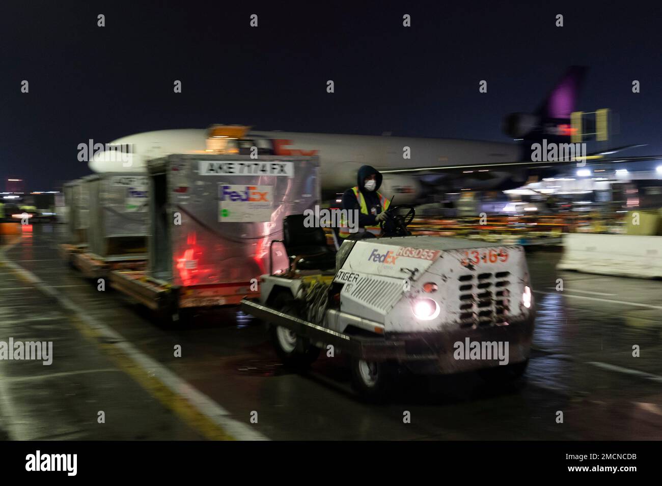 A cargo handler drives a tug at the FedEx regional hub at the Los ...