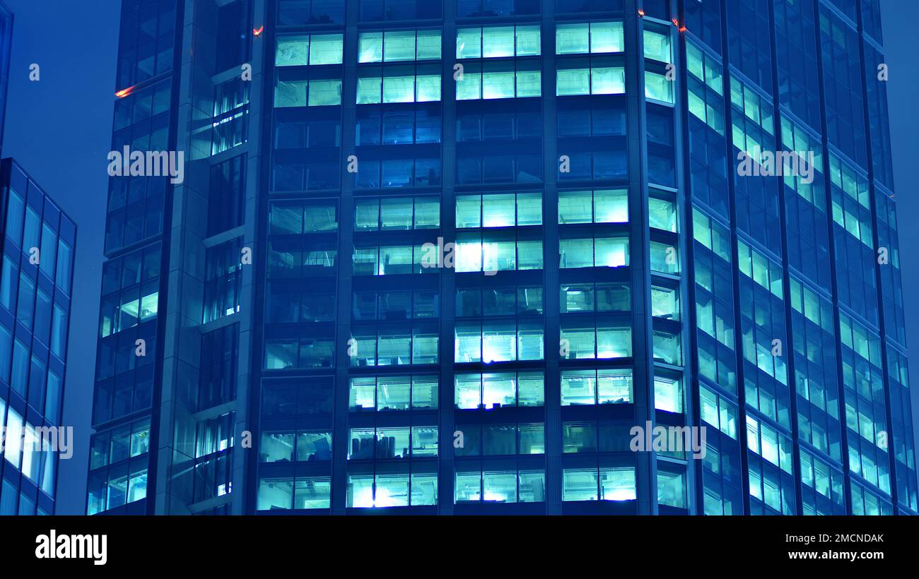 Pattern of office buildings windows illuminated at night. Glass ...