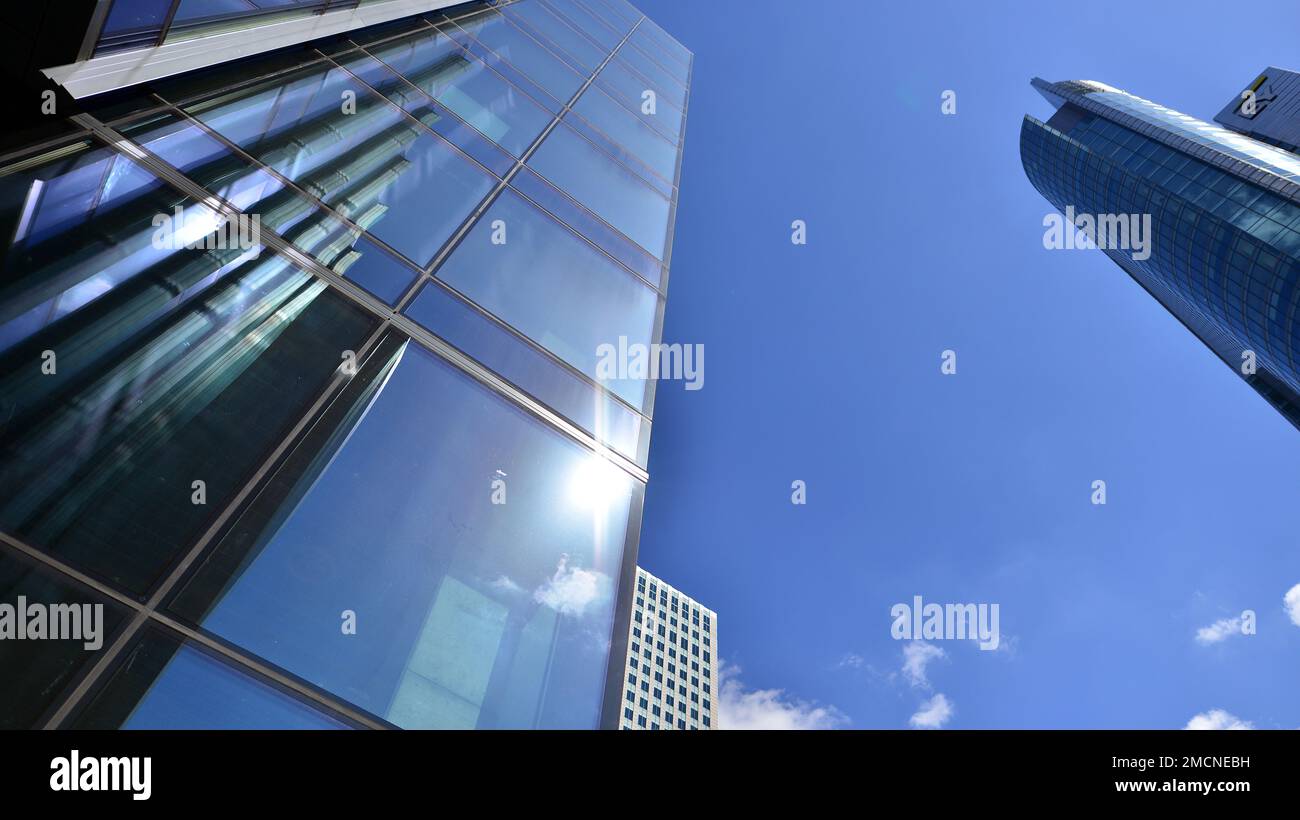 Modern glass facade against blue sky. Bottom view of a building in the ...
