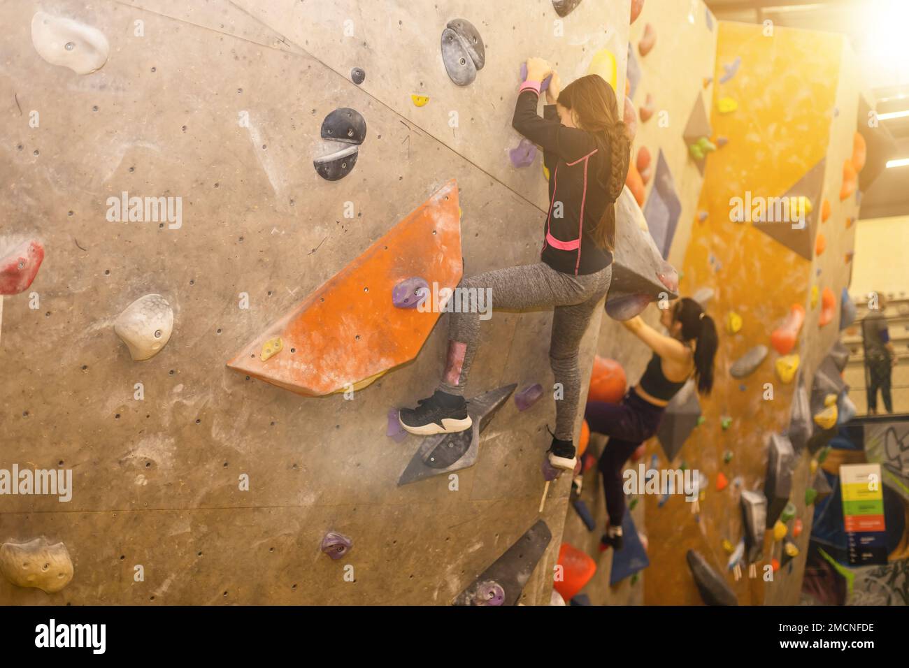 Teenage girl at indoor climbing wall. Kid having fun at bouldering wall ...