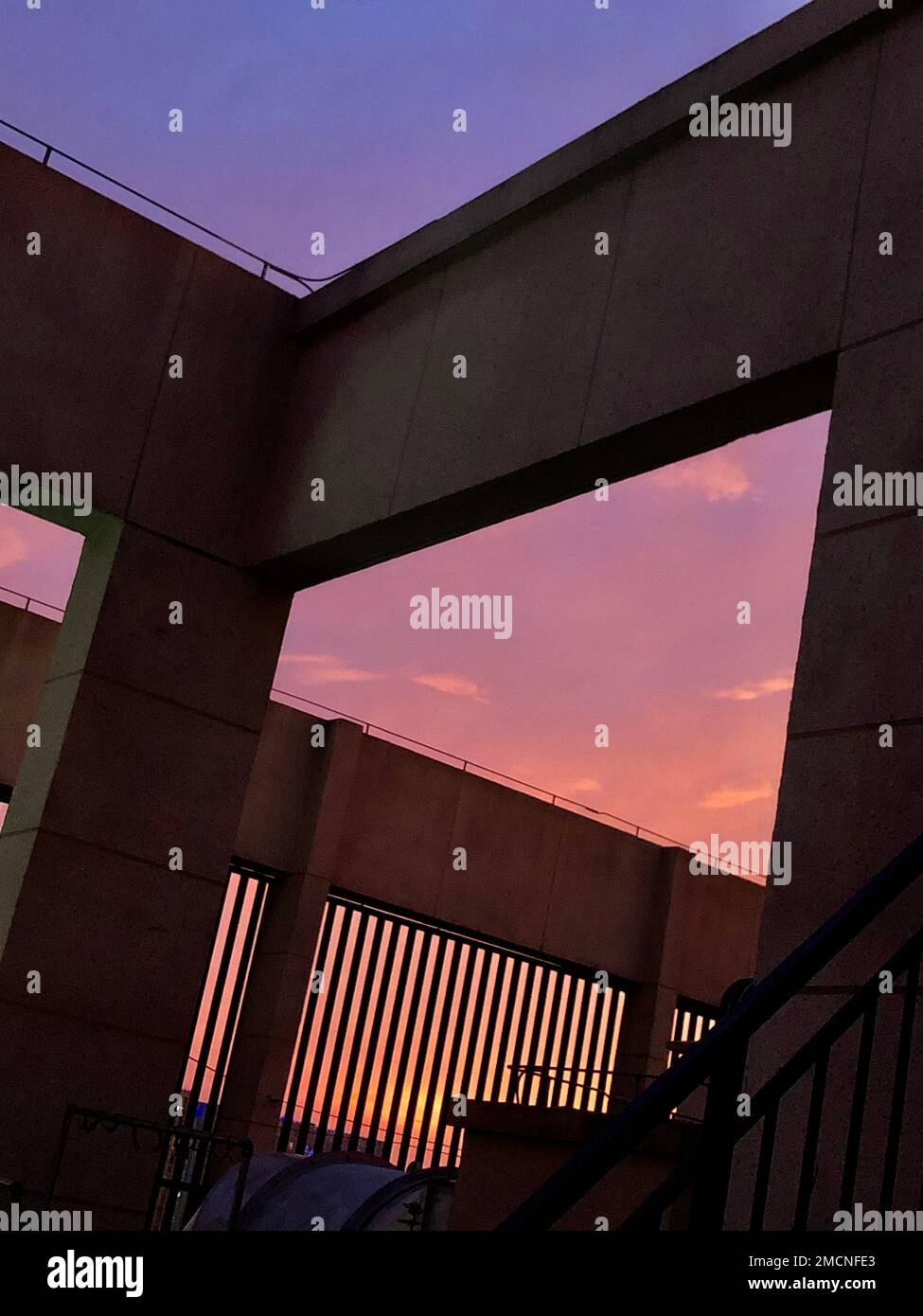 Purple sunset sky seen through unroofed building and fence Stock Photo ...