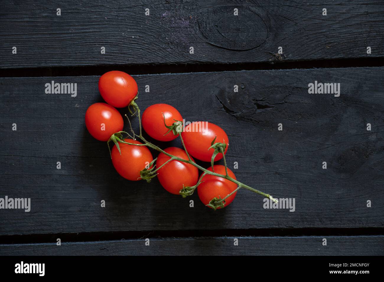 cherry tomatoes on black wooden background, tomato Stock Photo - Alamy