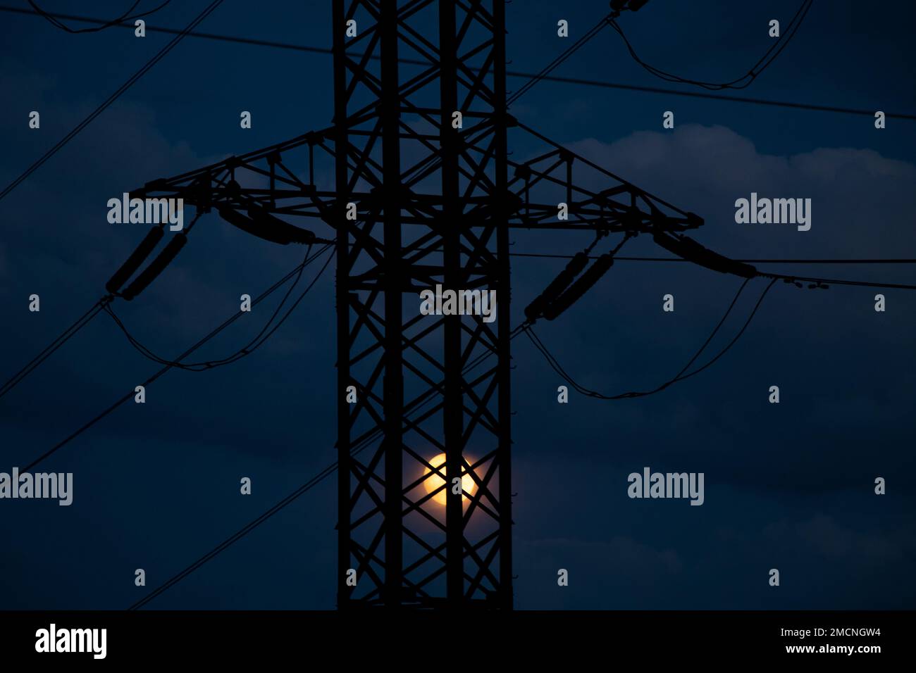 power line against the background of the moon in the sky at sunset at ...