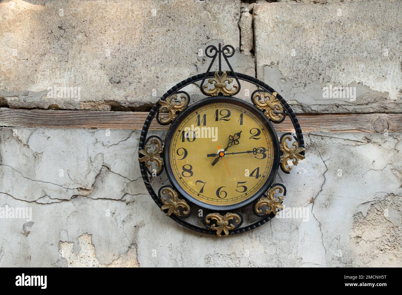 old broken clock ussr hangs on the white wall of a house in the street ...