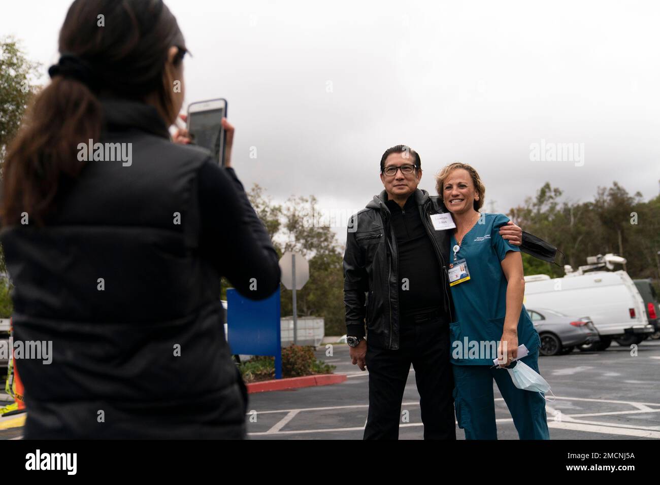 Former COVID-19 patient, Lorenzo Julius, center, poses for photos with his physical therapist ...