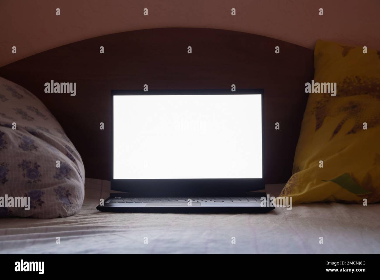 laptop with white screen stands on the bed in the bedroom at home ...