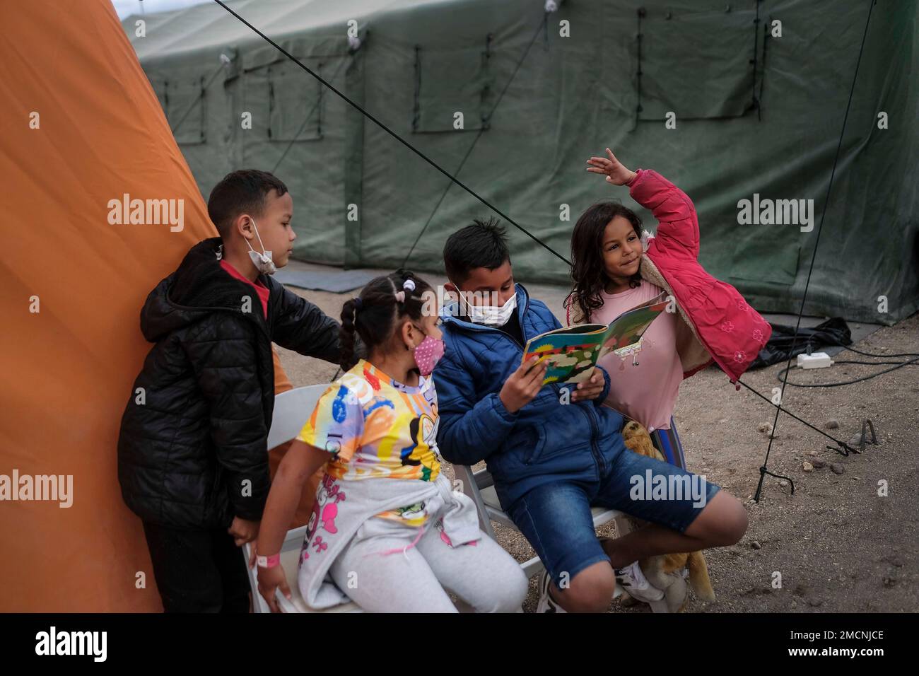 Children read at a camp after crossing into Chile from Bolivia, in ...