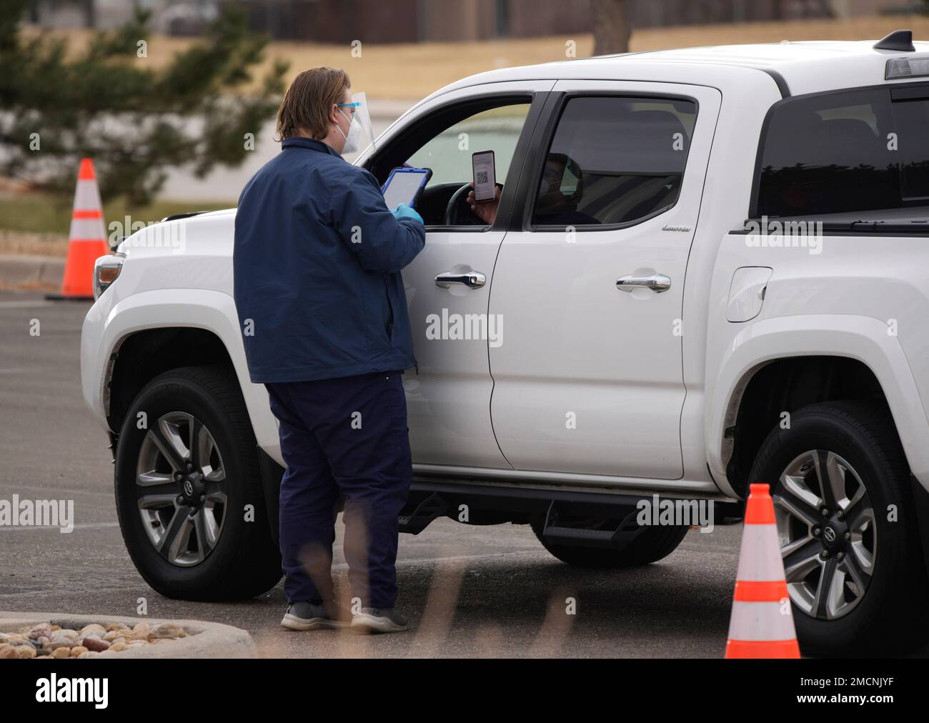 A worker checks in a client at a drive-up COVID-19 testing station ...