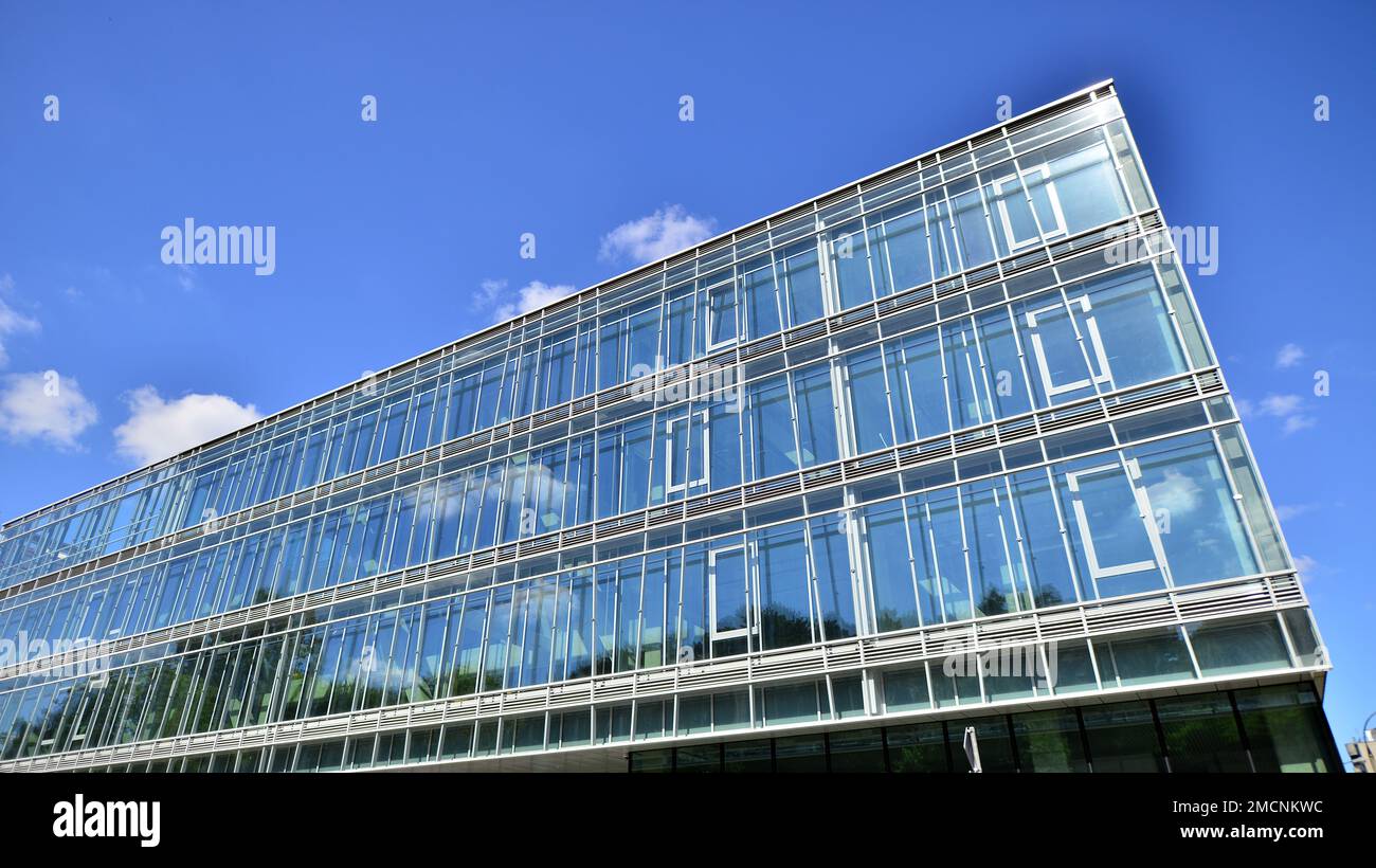Modern glass facade against blue sky. Bottom view of a building in the ...