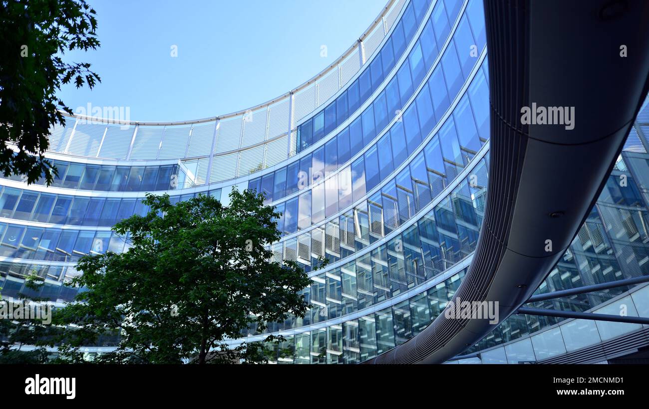 Modern glass facade against blue sky. Bottom view of a building in the ...