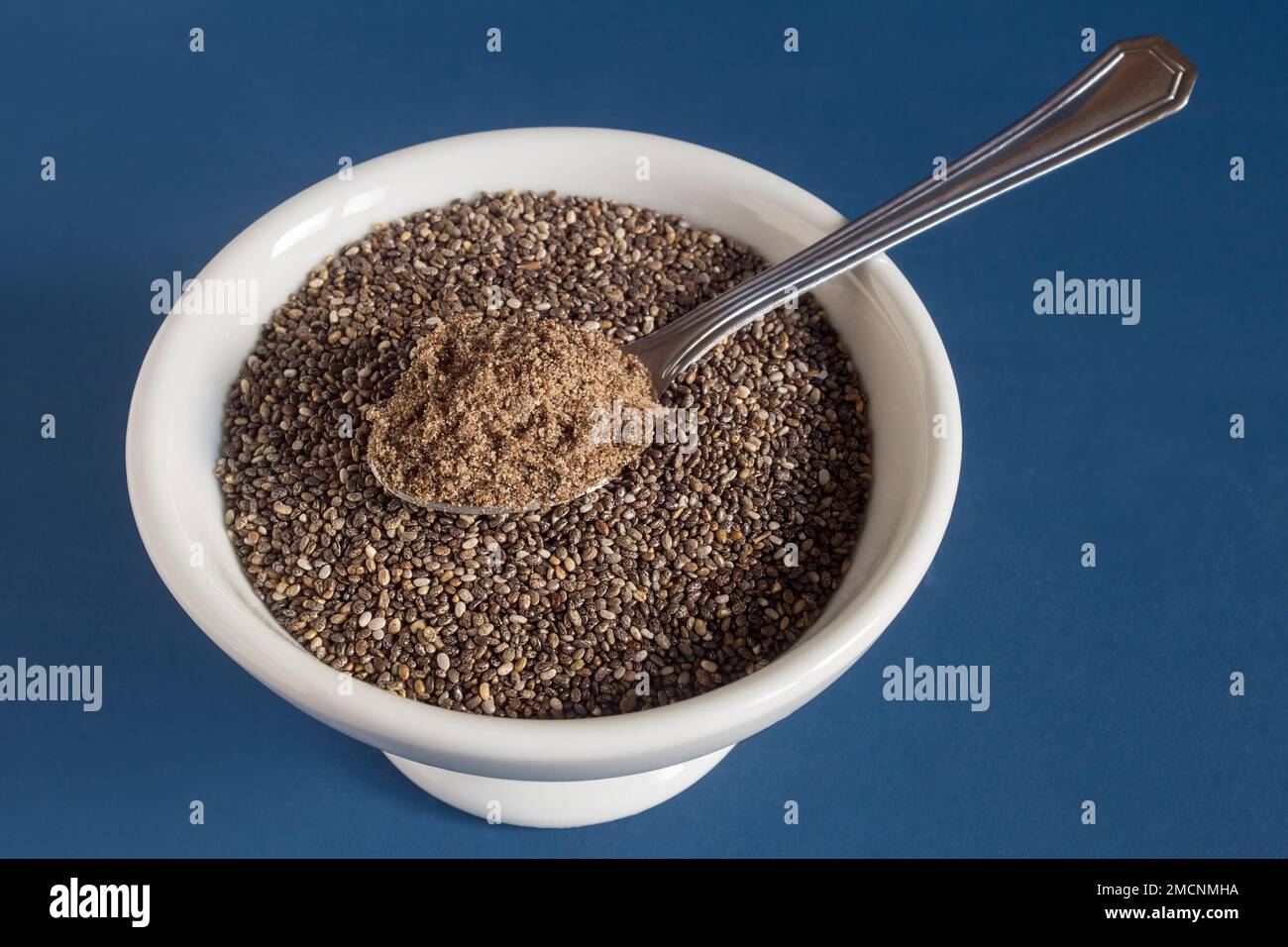 A teaspoon of chia powder over a small bowl filled with whole chia ...