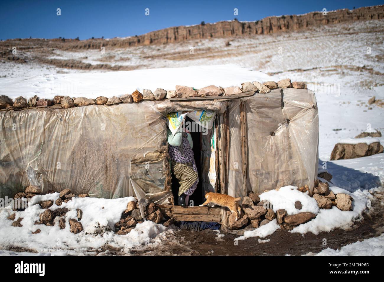 Awoman stands outside her home amidst the snow in the Amazigh Timahdite ...