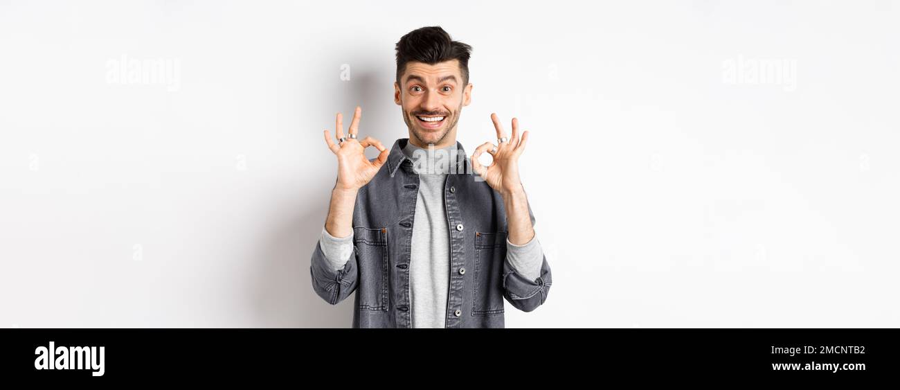 Happy guy say yes, smiling and showing okay signs, like good product ...