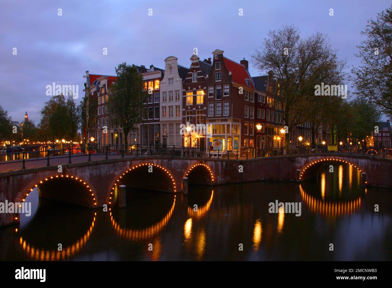Night time view of a canal in Amsterdam with lights reflected in the ...
