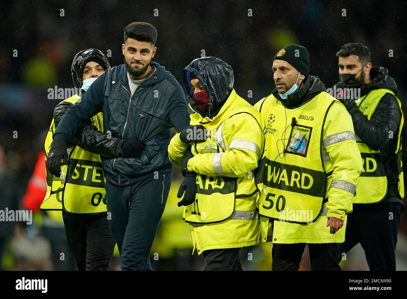 Stewards escort a man after he ran onto the pitch during the Champions ...