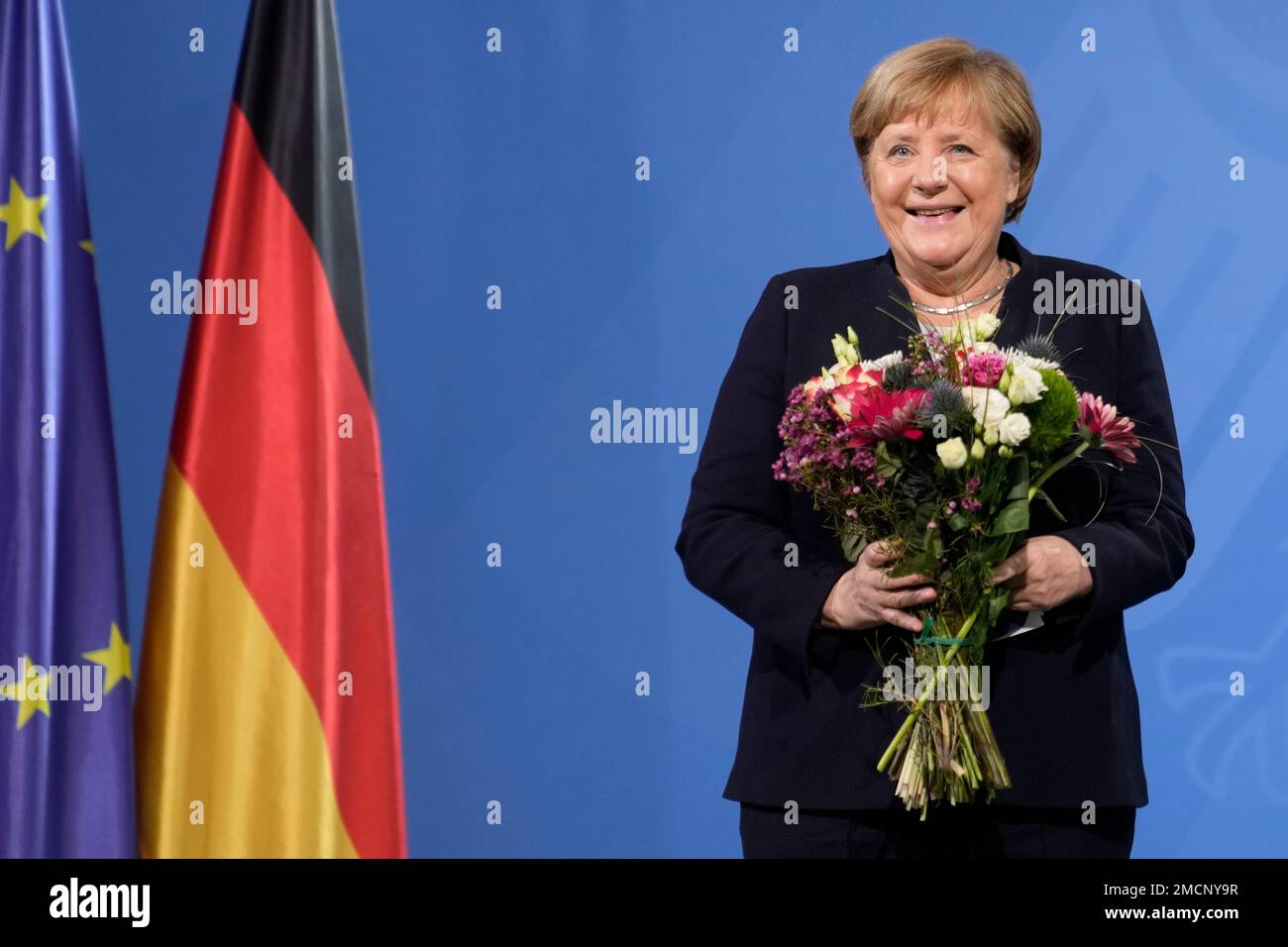Former Chancellor Angela Merkel laughs as she receives flowers from new ...