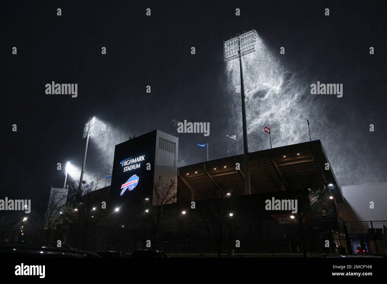A snow flurry is lit by stadium lights before an NFL football game ...