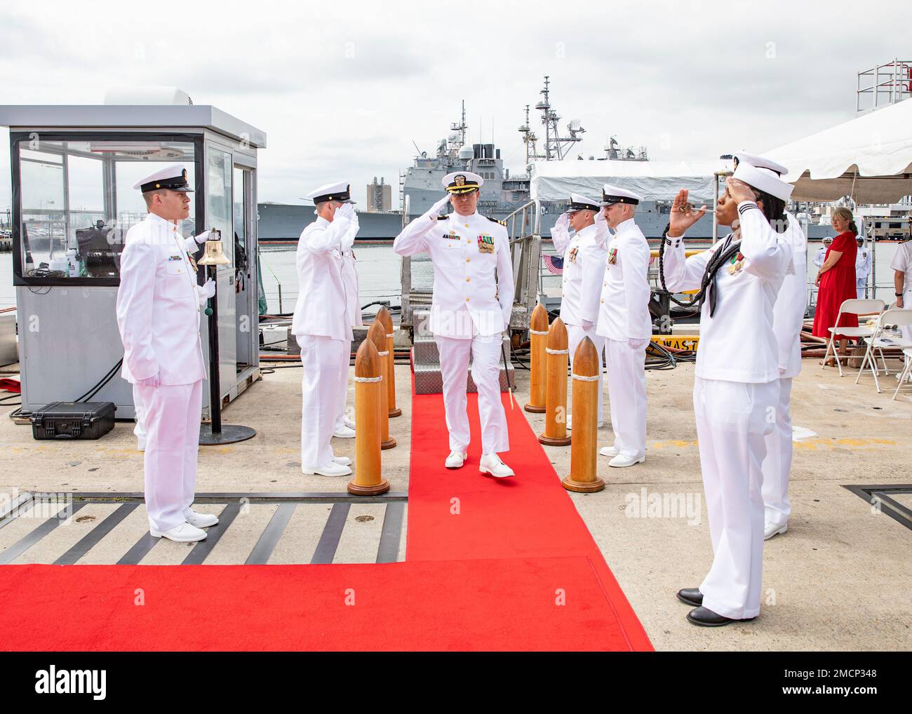 Cmdr. Clint Christofk renders a salute to sideboys as he departs a ...