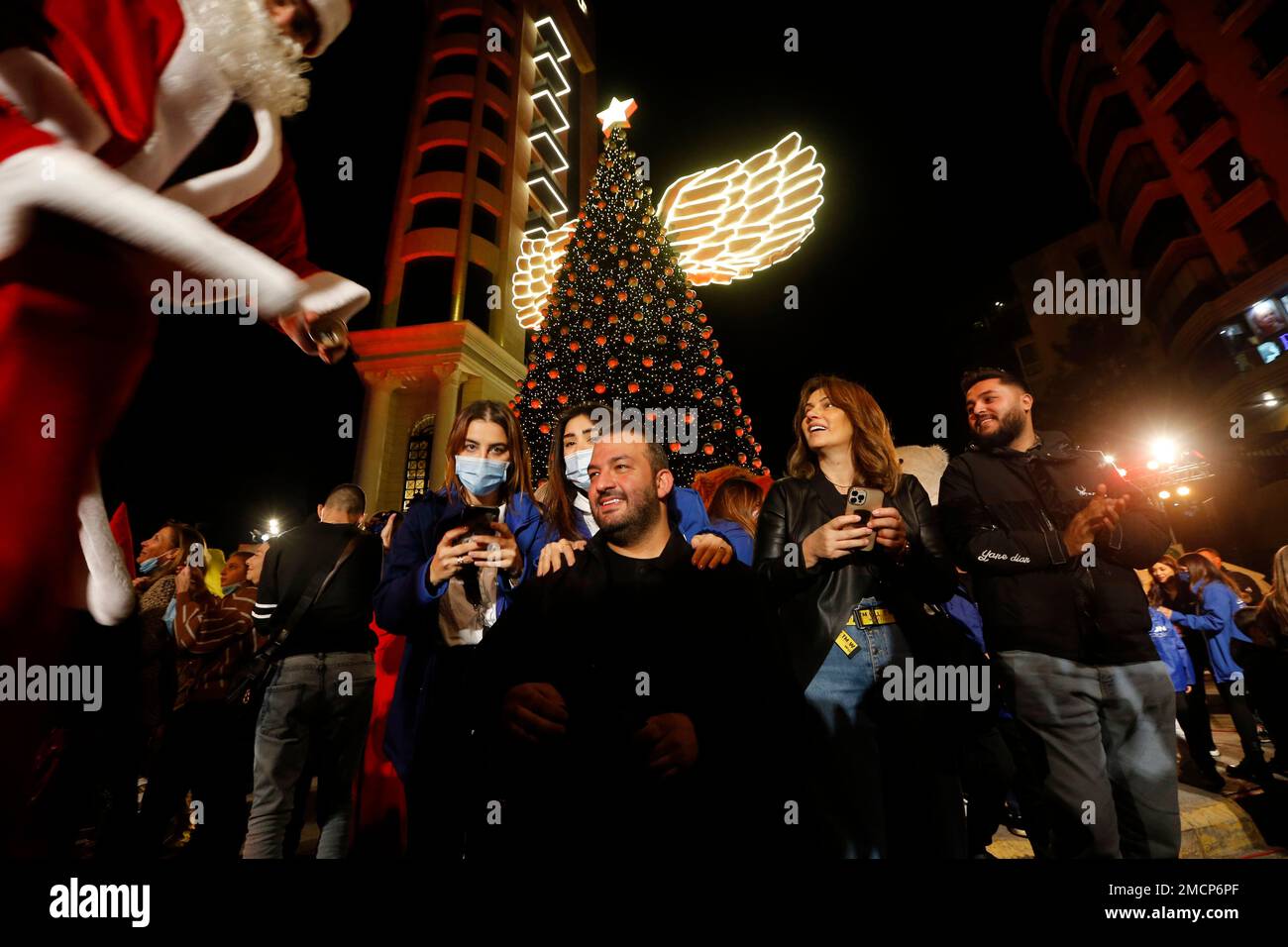 People gather during the illumination of a giant Christmas tree at the ...
